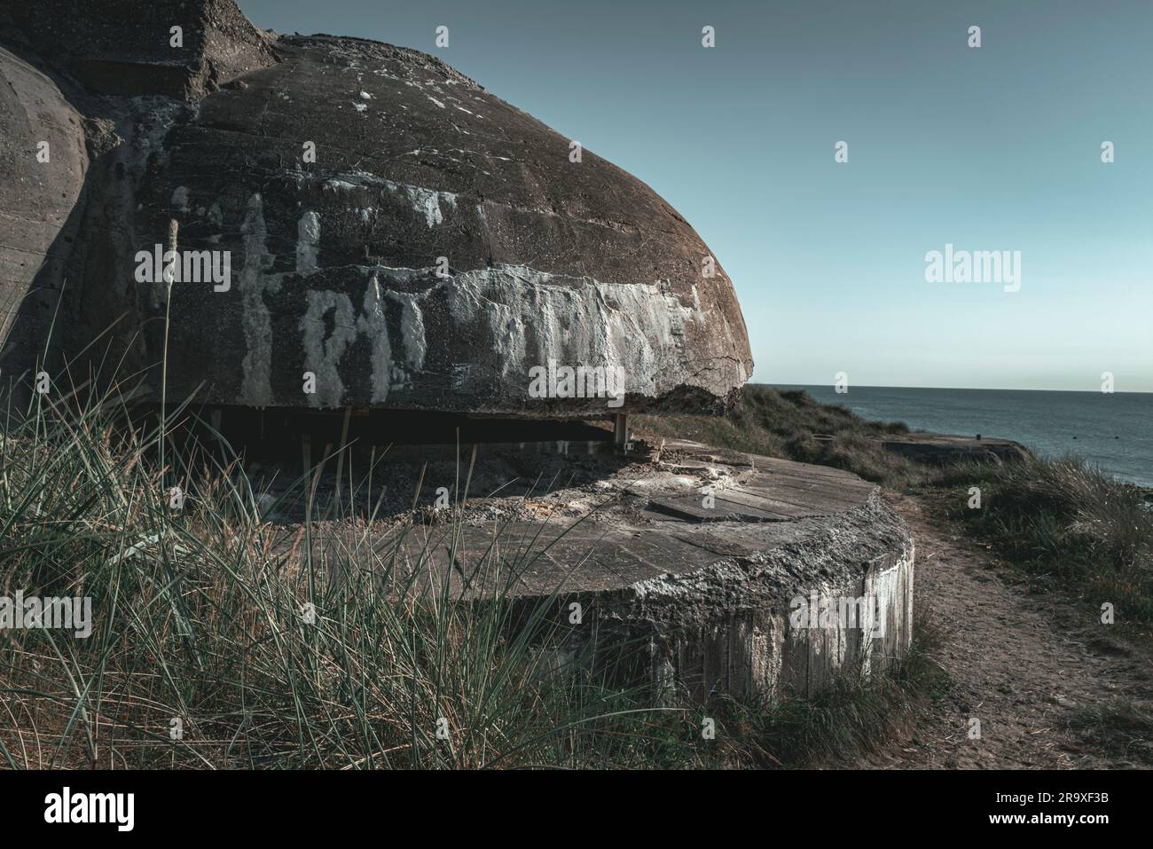 This image features an abandoned World War II bunker located on a beach ...