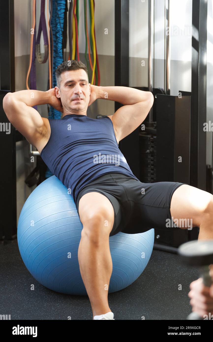 mature fitness man doing abdominal crunches at the gym on a pilates ...