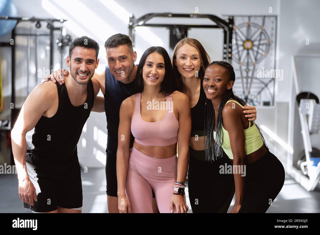 multicultural fitness group posing and smiling looking at the camera in ...