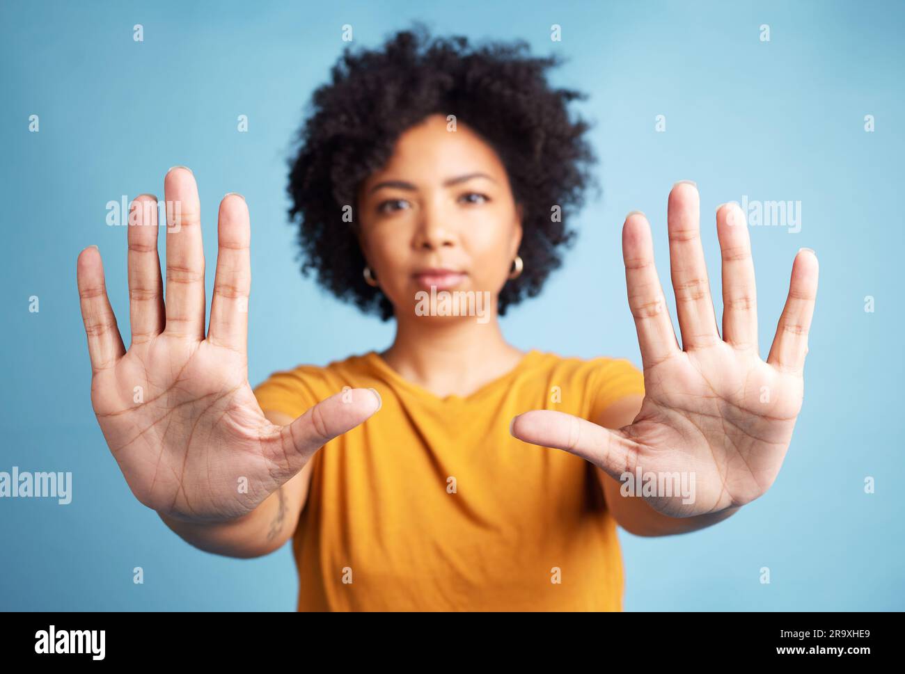 Portrait, stop hands and serious woman in studio isolated on a blue ...