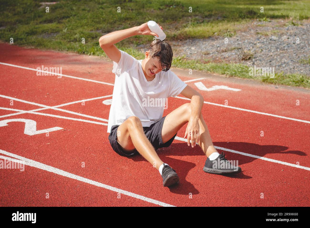 Young athlete refreshes himself with water after a hard workout on the ...