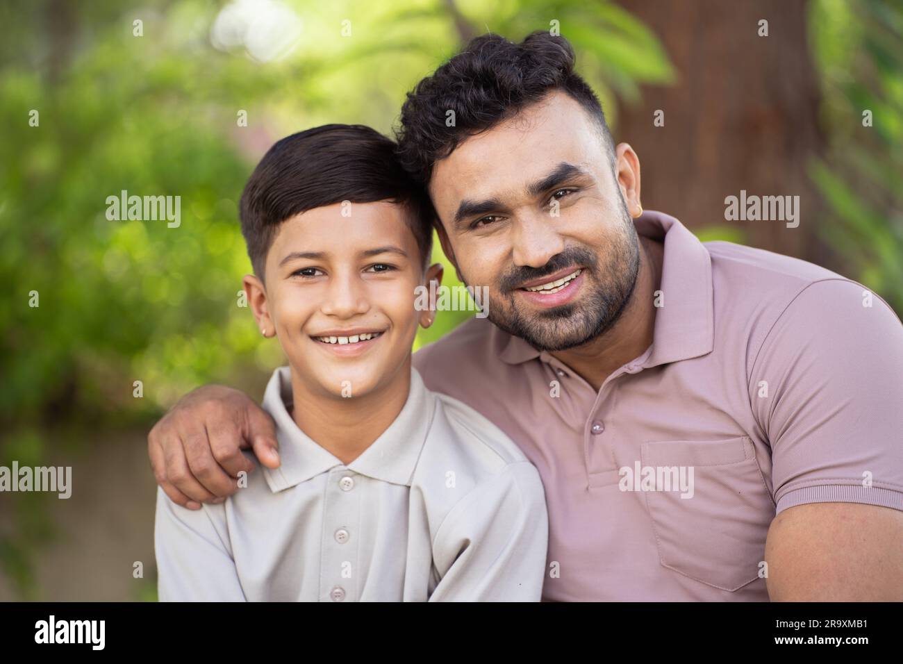 Happy smiling indian father with son embracing each other by looking ...