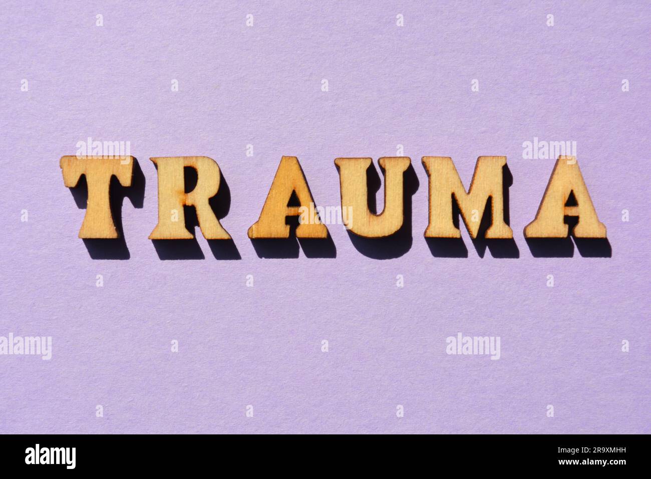 Trauma, word in wooden alphabet letters isolated on purple background ...