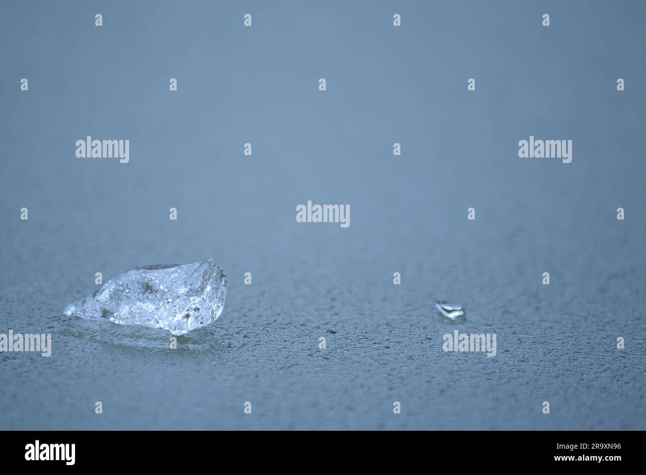 Two transparent chunks of ice on a frozen surface of water Stock Photo ...