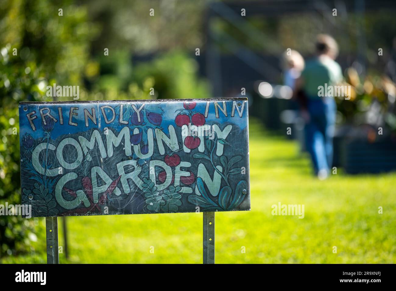 community garden sign at a vegetable garden with a mother and baby in a ...