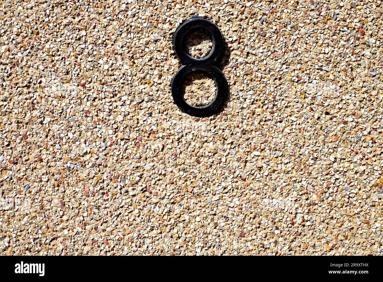Numeral 8 / eight black on warm tone stone wall Stock Photo - Alamy