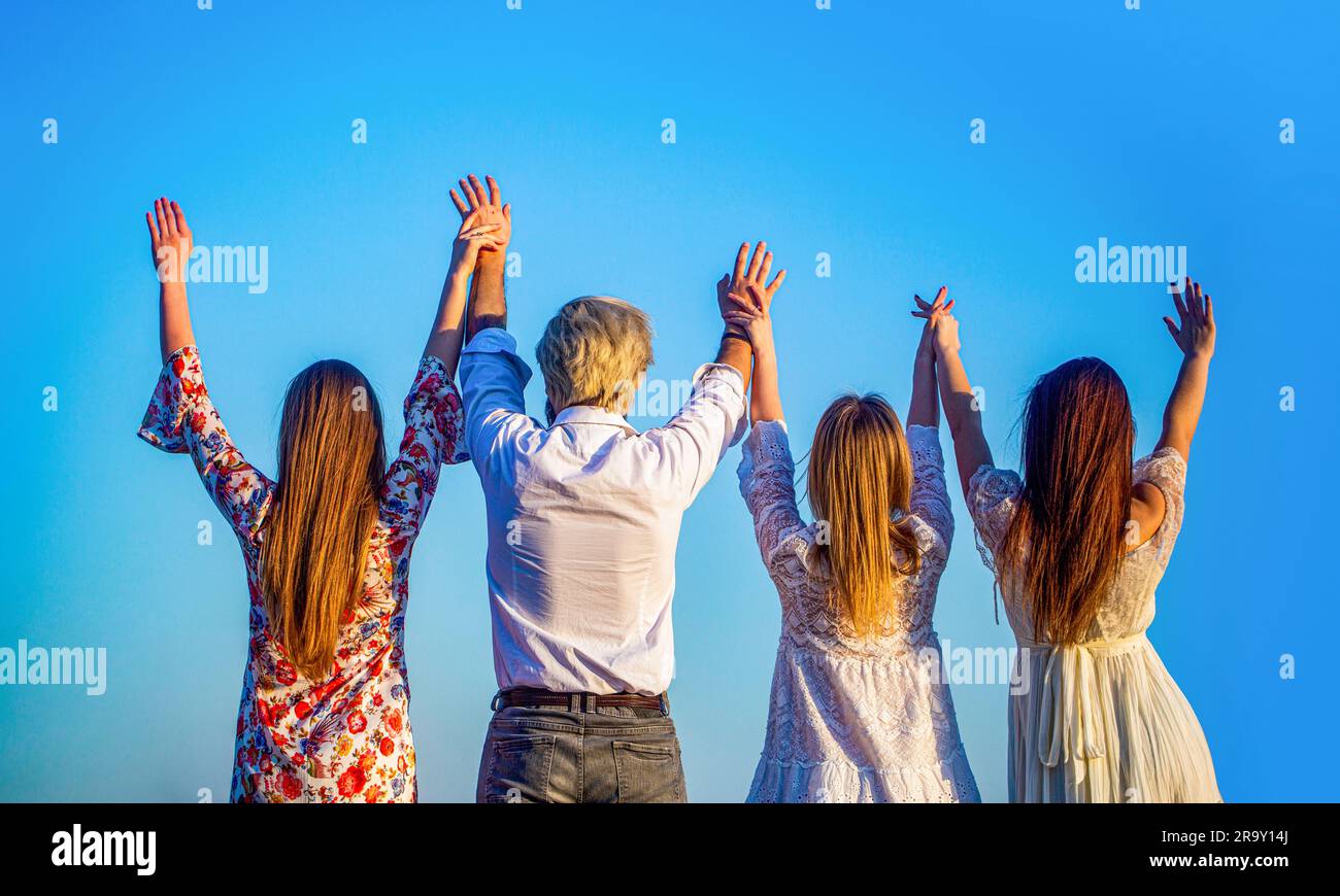 Group, hands up back. Group of women, man enjoying and together saying ...