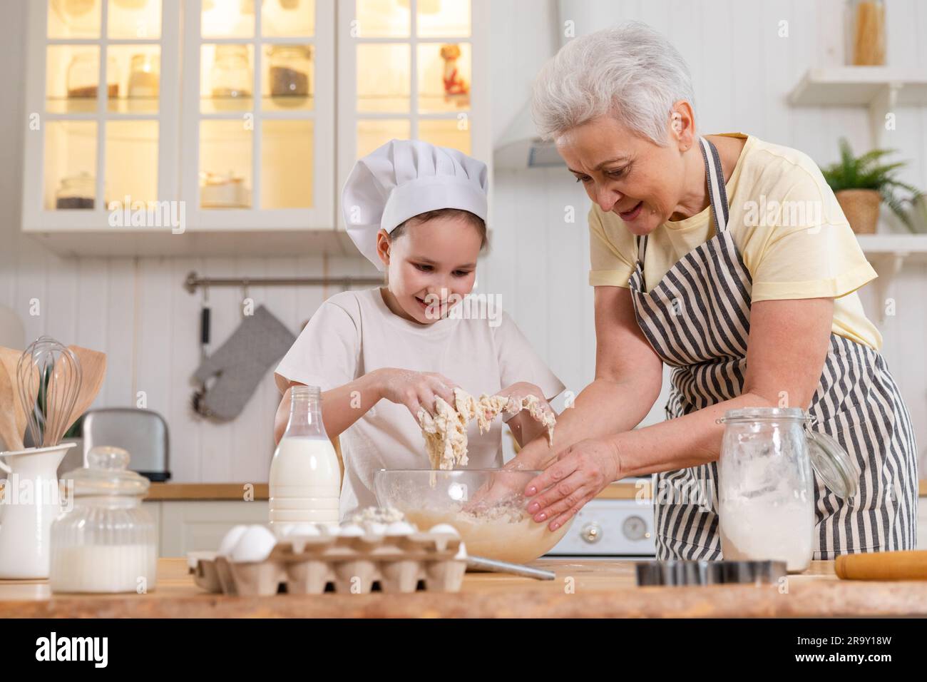 Happy family in kitchen. Grandmother and granddaughter child cook in ...