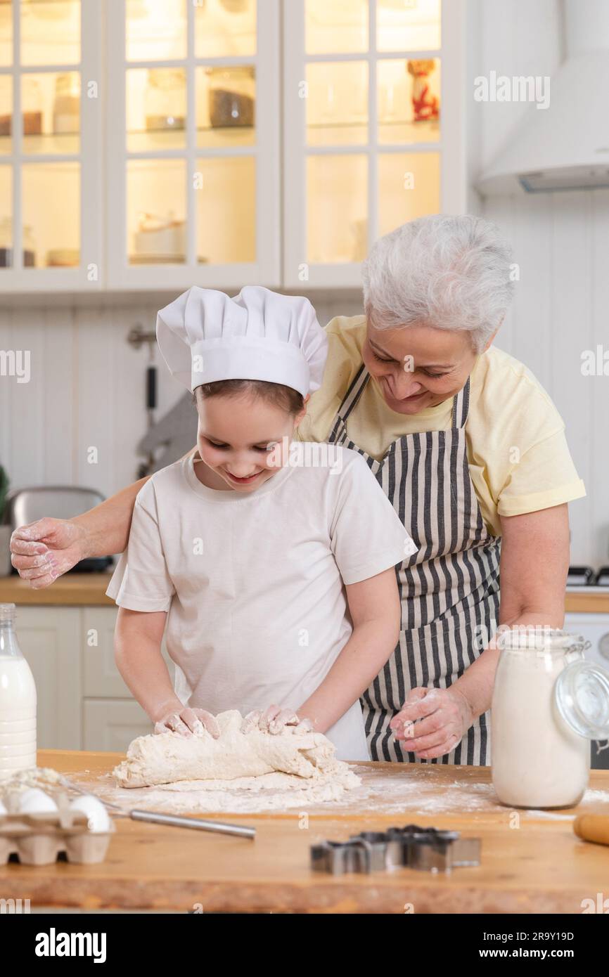 Happy family in kitchen. Grandmother and granddaughter child cook in ...