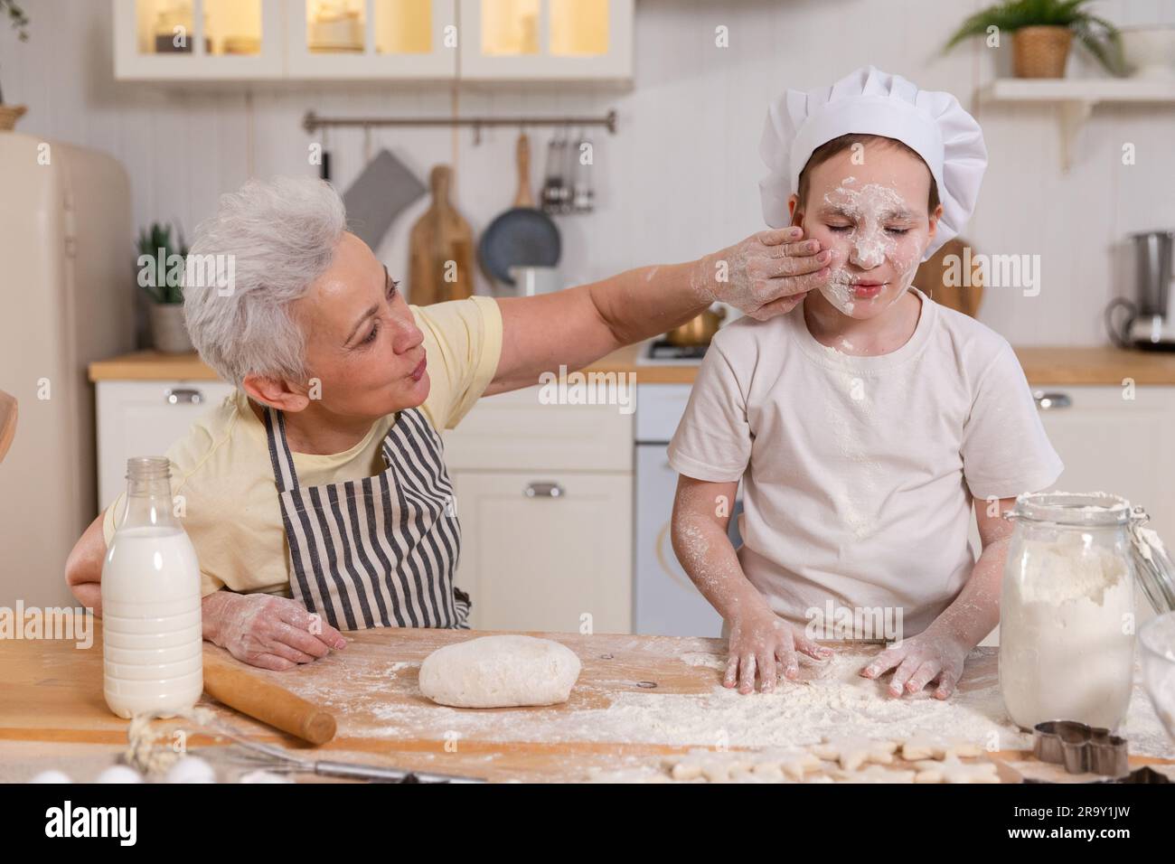 Happy family in kitchen. Grandmother and granddaughter child cook in ...