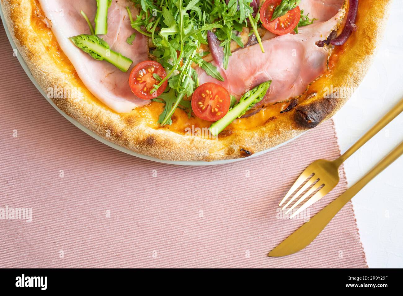 Tasty ham pizza with rosemary ham, asparagus, tomatoes, and arugula ...