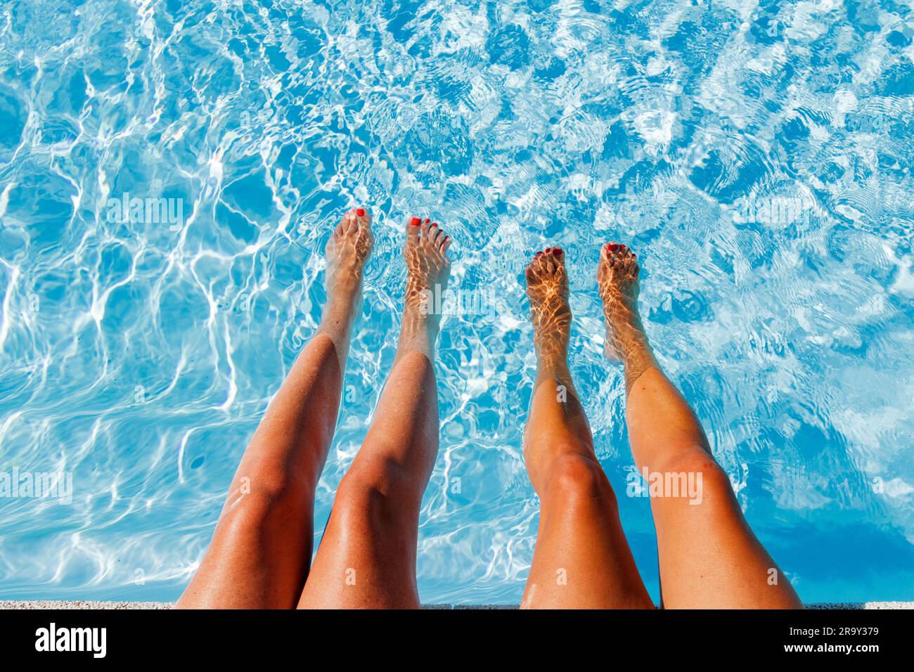 The two women's legs in the water above the pool Stock Photo - Alamy
