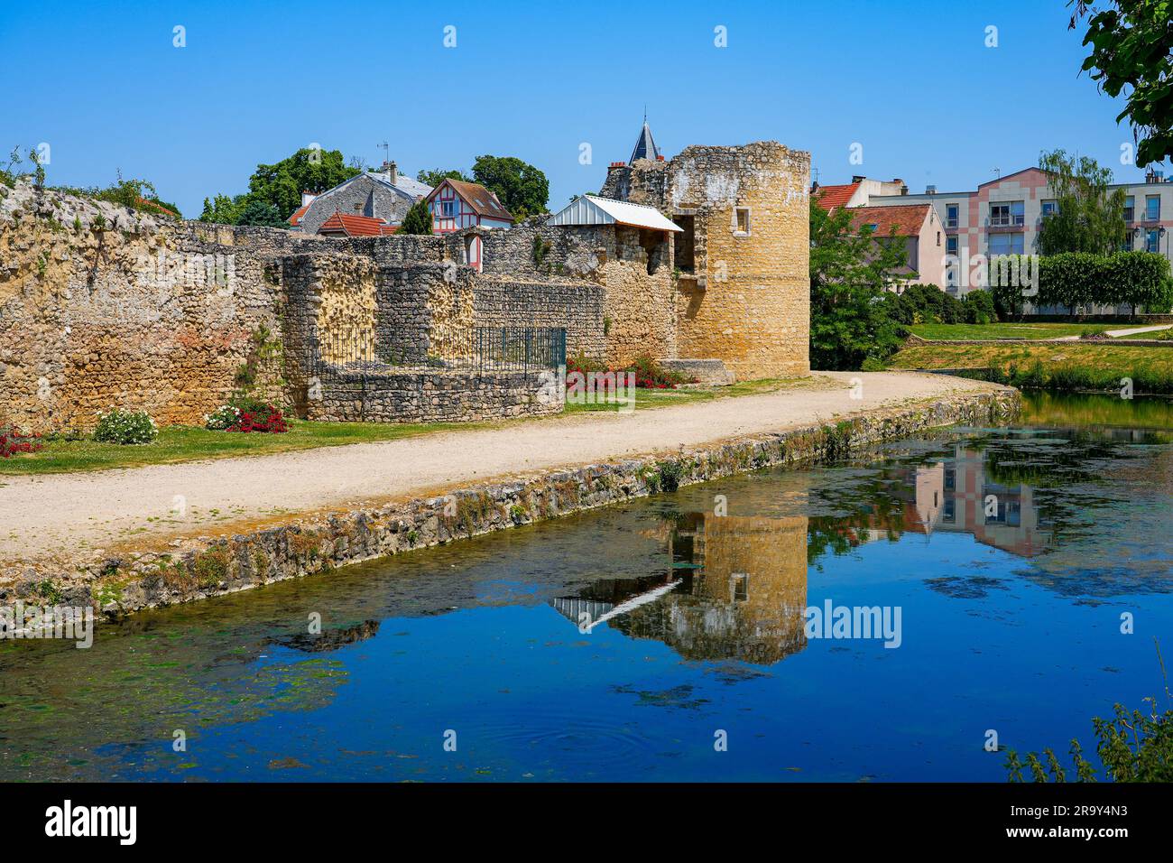 Water-filled moat below the round corner tower of the medieval castle ...