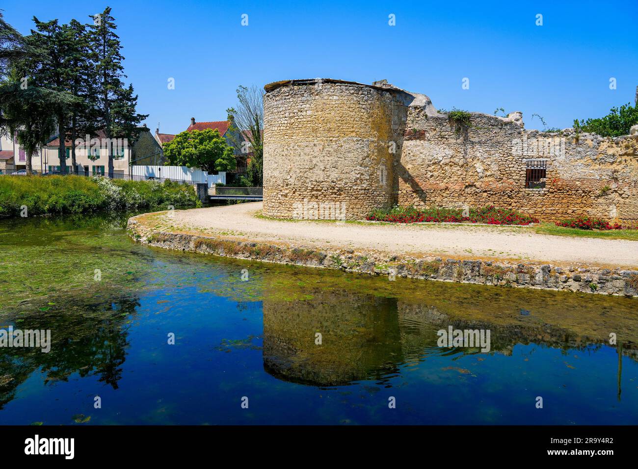 Water-filled moat below the round corner tower of the medieval castle ...