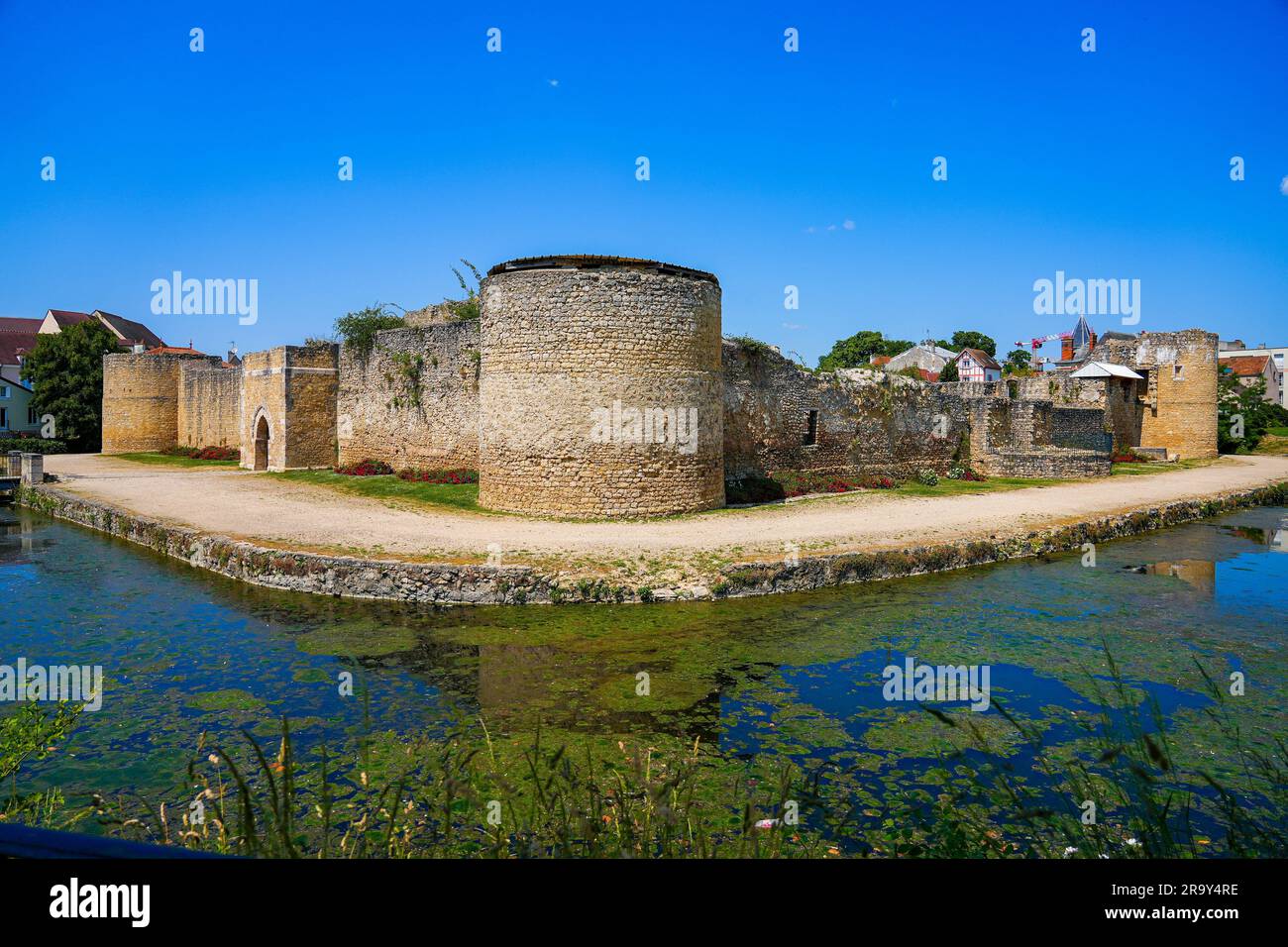 Water-filled moat below the round corner tower of the medieval castle ...
