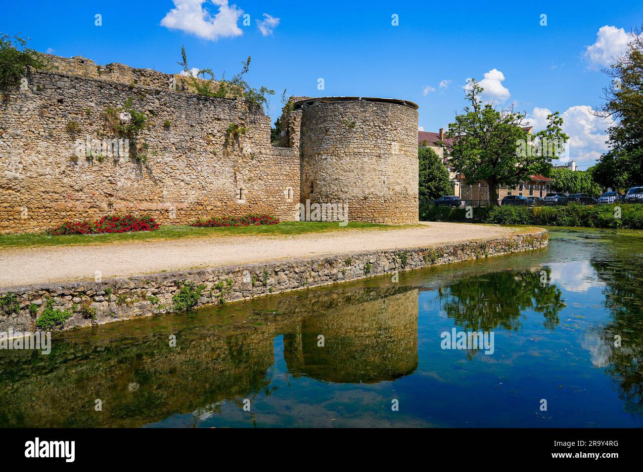 Water-filled moat below the round corner tower of the medieval castle ...