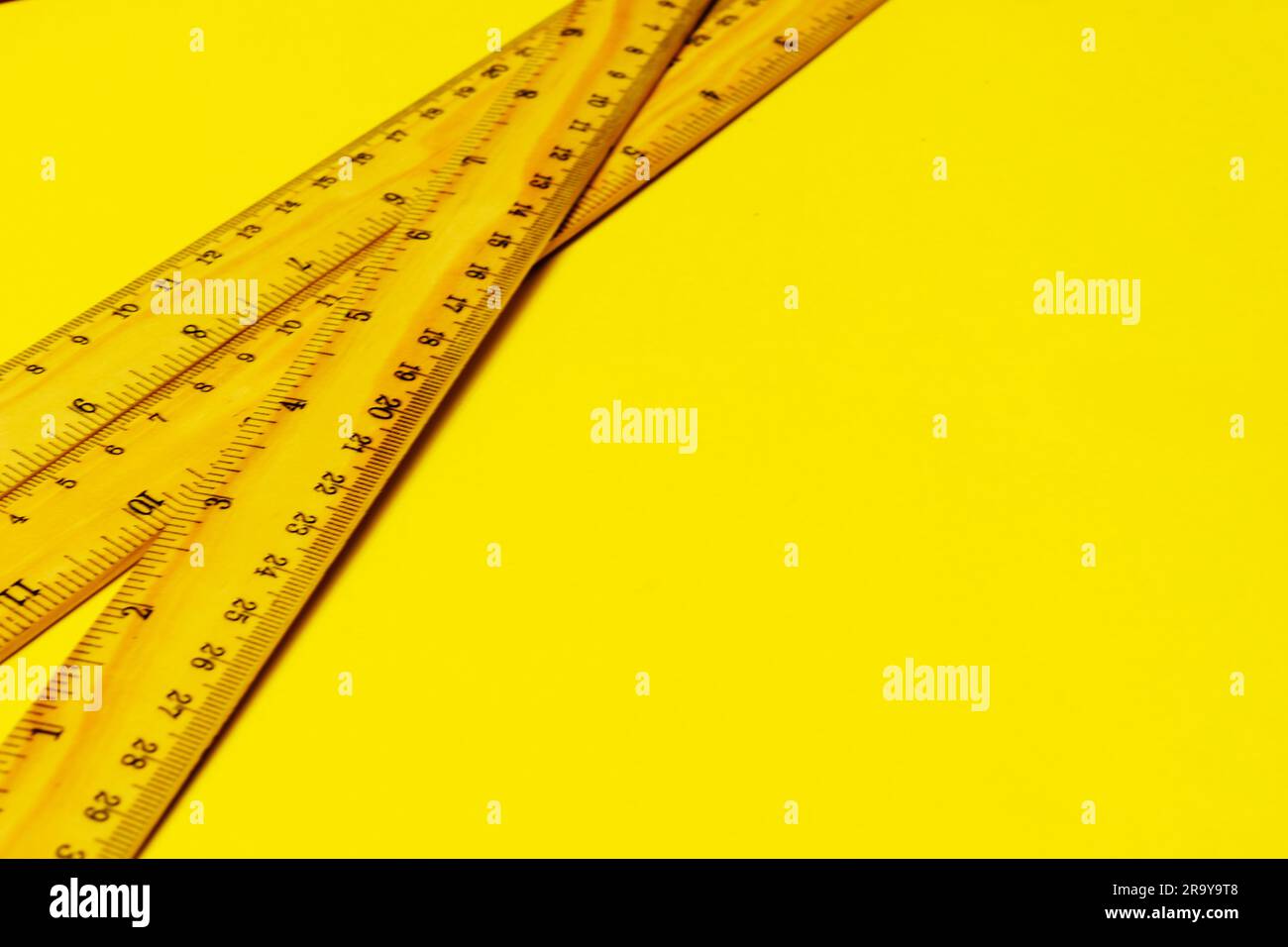 Close up of rulers from metric and imperial system on plywood room for ...