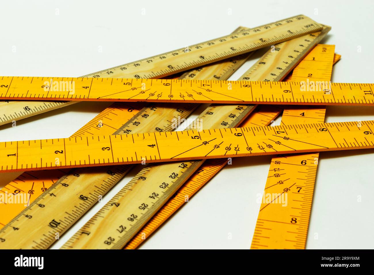 Close up of rulers from metric and imperial system on plywood room for ...