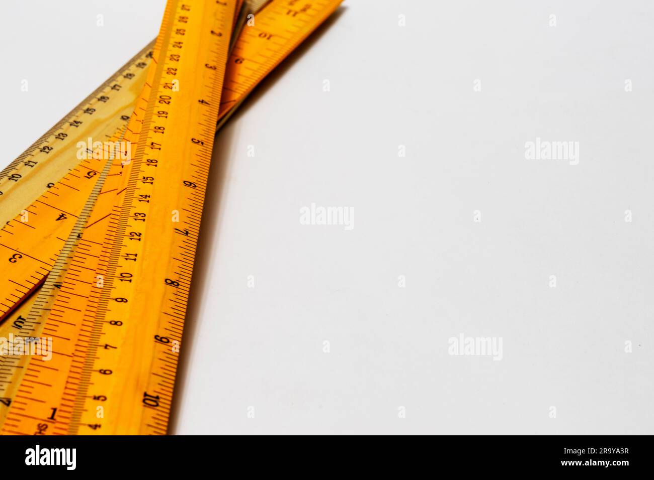 Close up of rulers from metric and imperial system on plywood room for ...