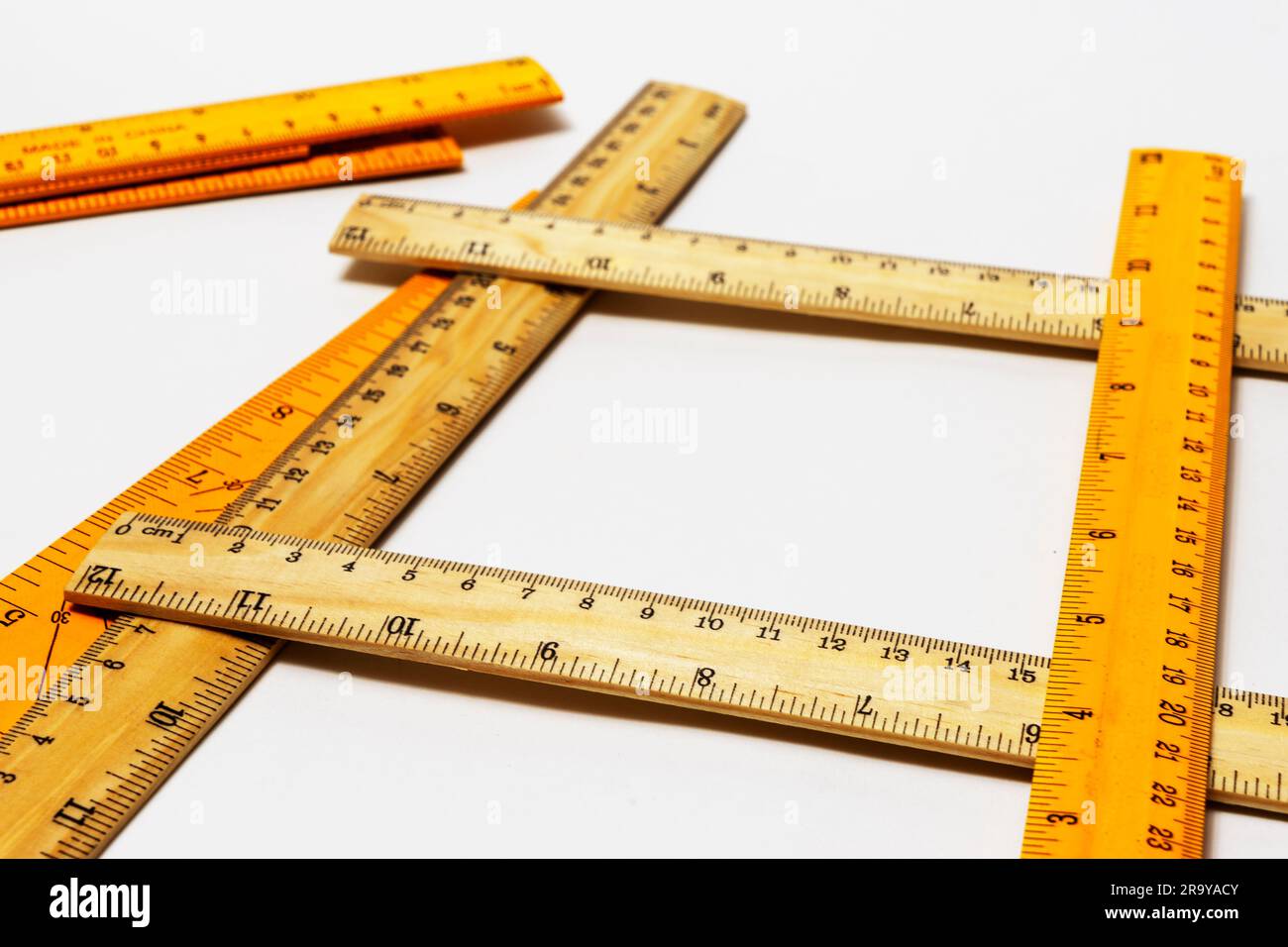 Close up of rulers from metric and imperial system on plywood room for ...