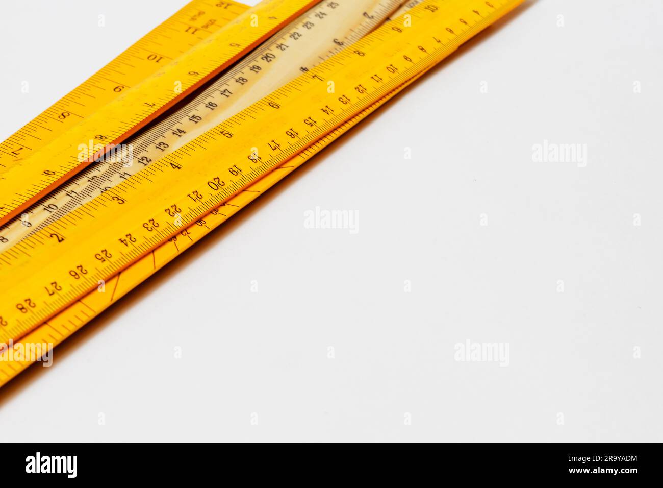 Close up of rulers from metric and imperial system on plywood room for ...