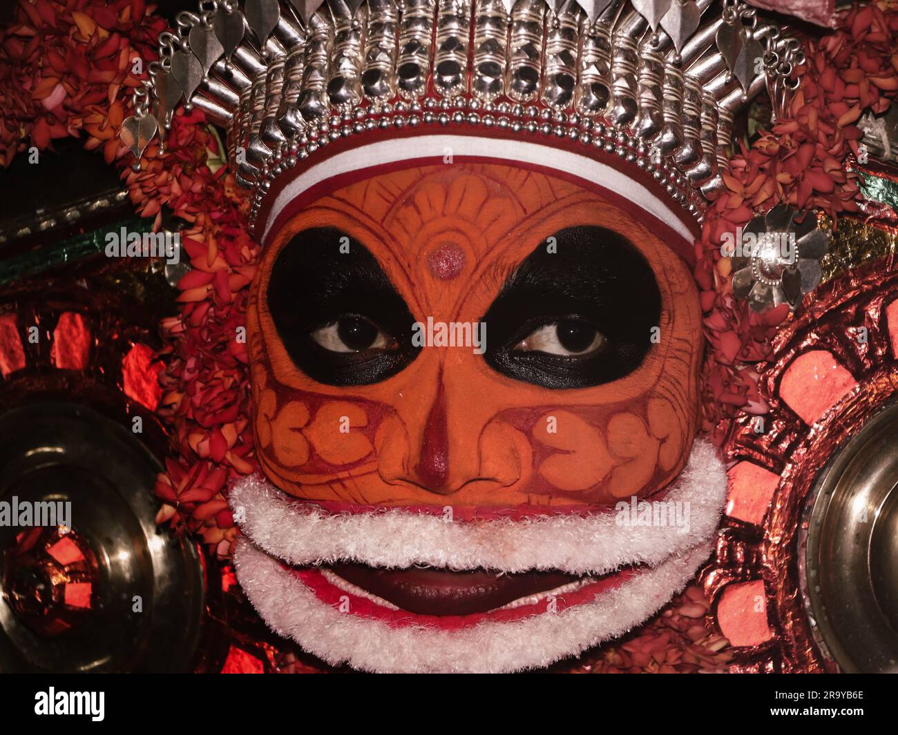 a closeup headshot portrait of a theyyam artist decorated with ...