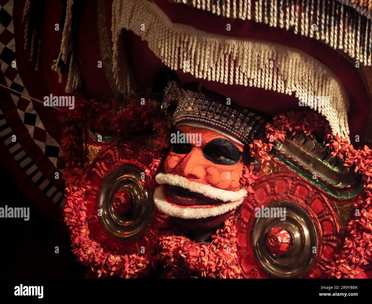 closeup of bright colored and decorated theyyam, a traditional artform ...