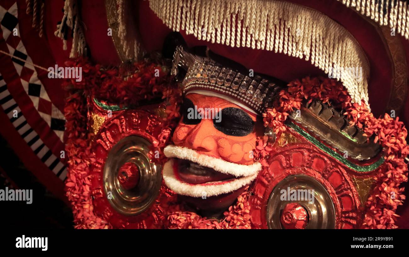 closeup of bright colored and decorated theyyam, a traditional artform ...