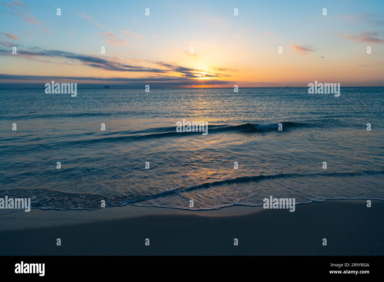 scenic sunset with sea water on the summer beach Stock Photo - Alamy