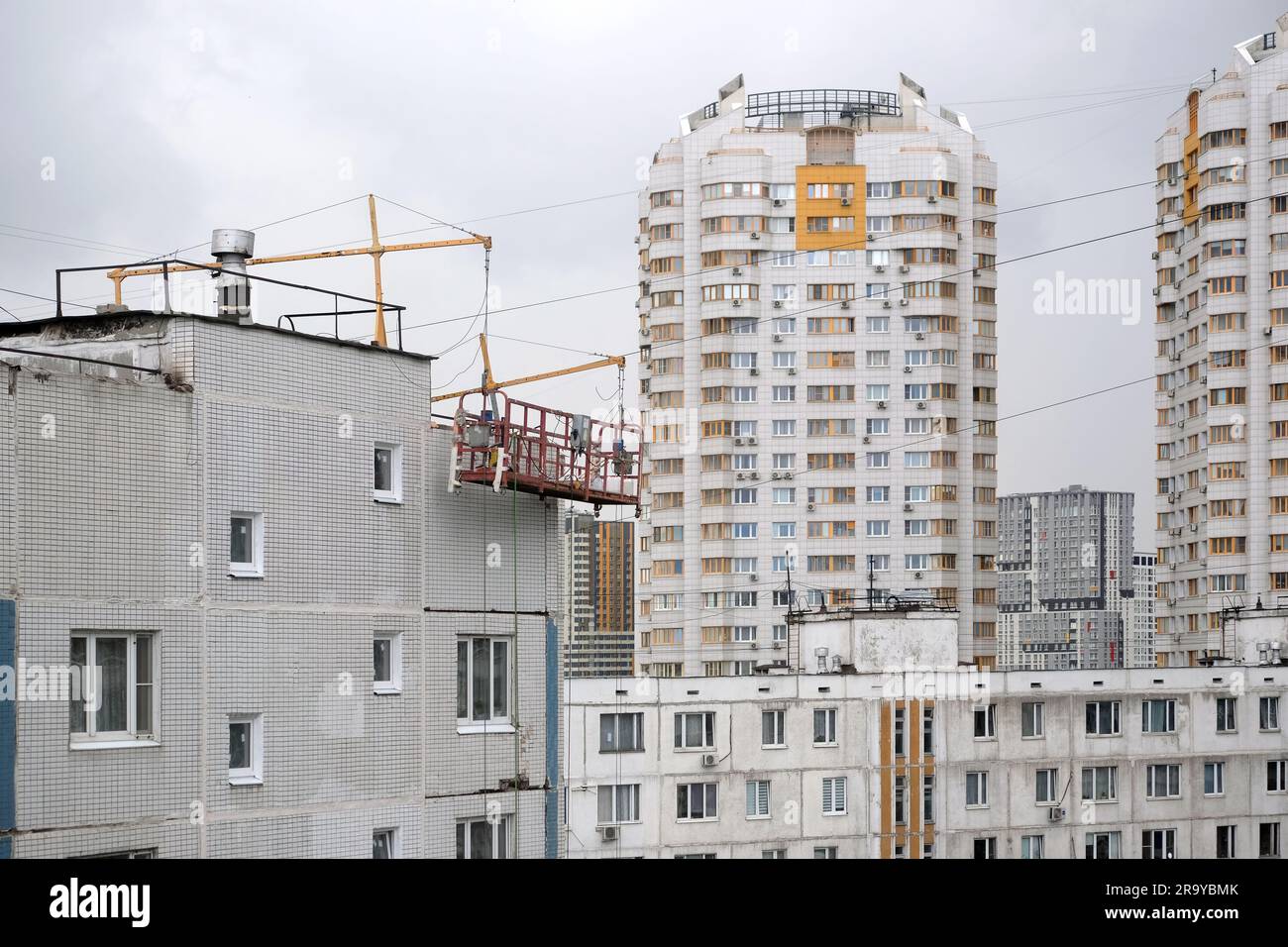 Break during work. Empty construction cradle on metal cables on the ...