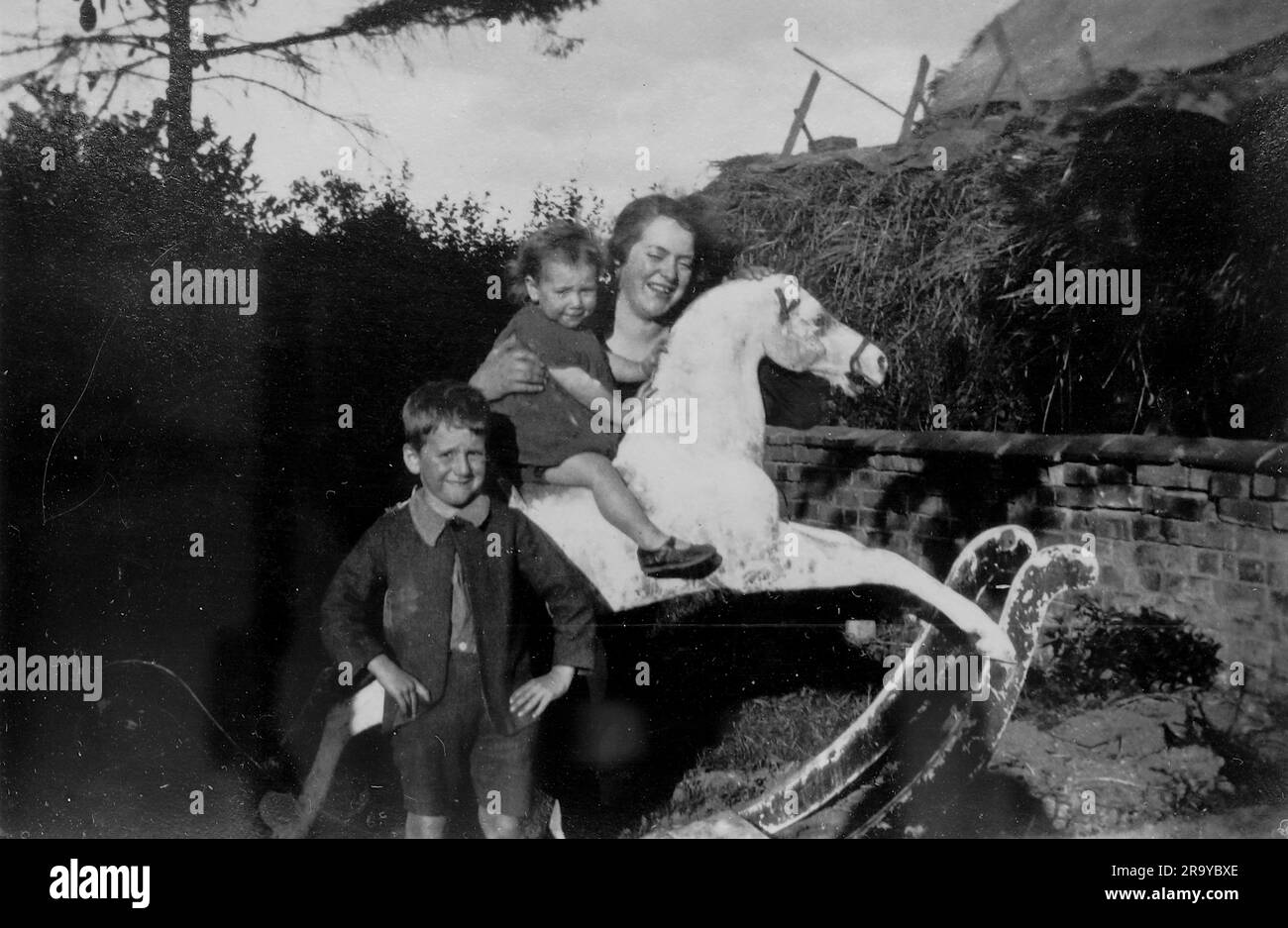A lady with two children and a rocking horse. Photo from a family album ...