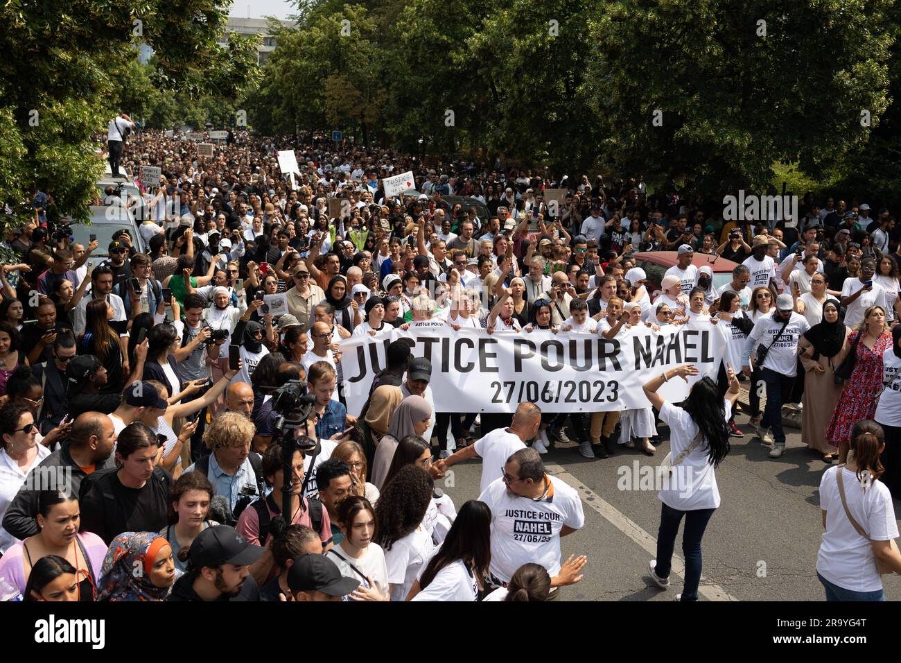 People hold a sign justice for Nahel during a commemoration march ...