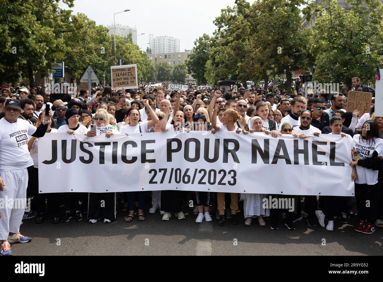People hold a sign justice for Nahel during a commemoration march ...