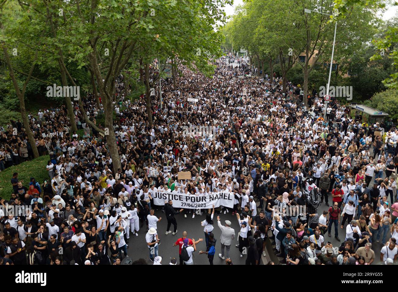 People hold a sign justice for Nahel during a commemoration march ...