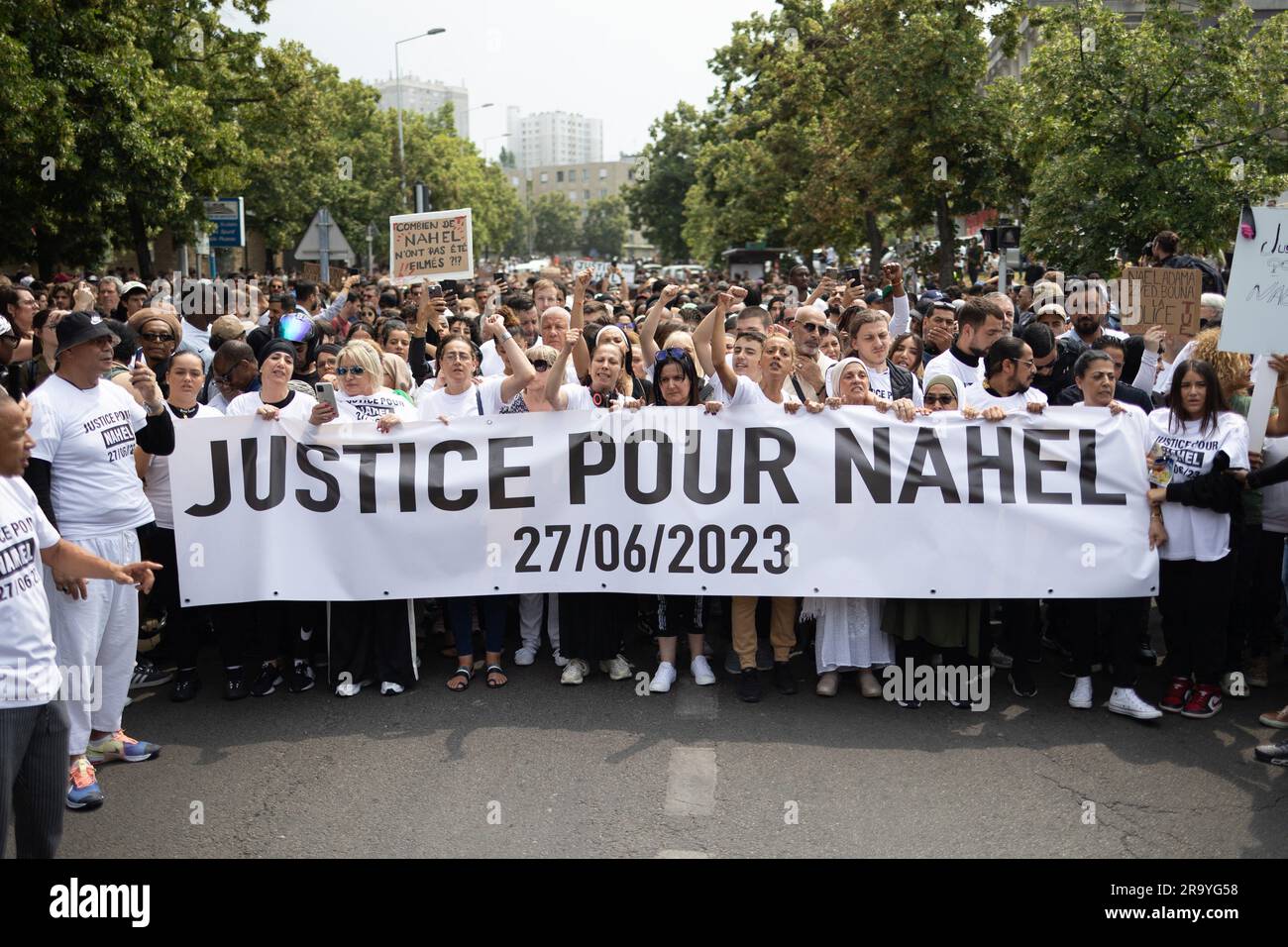 People hold a sign justice for Nahel during a commemoration march ...