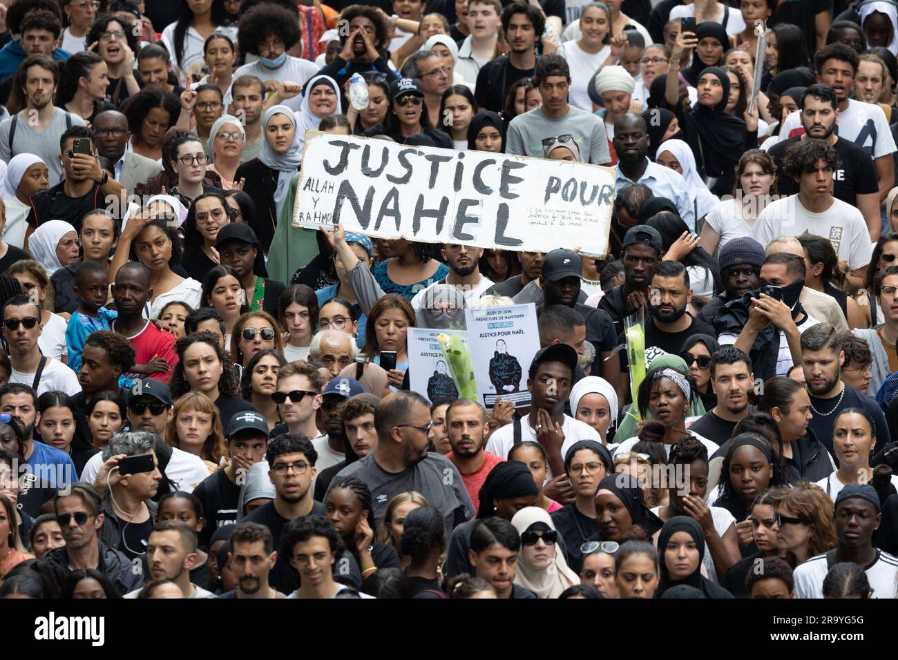 People hold a sign justice for Nahel during a commemoration march ...