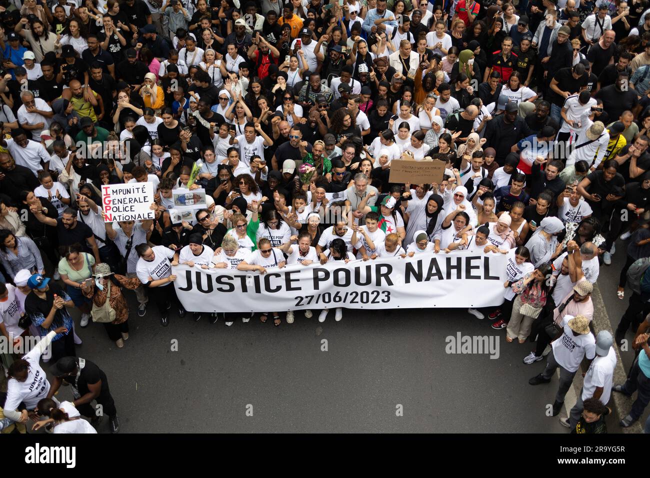 People hold a sign justice for Nahel during a commemoration march ...