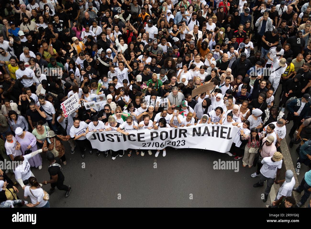 People hold a sign justice for Nahel during a commemoration march ...