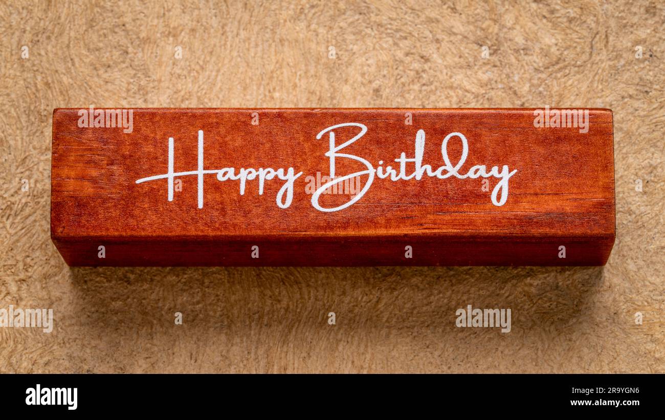 Happy Birthday text on wooden block against handmade bark paper in ...