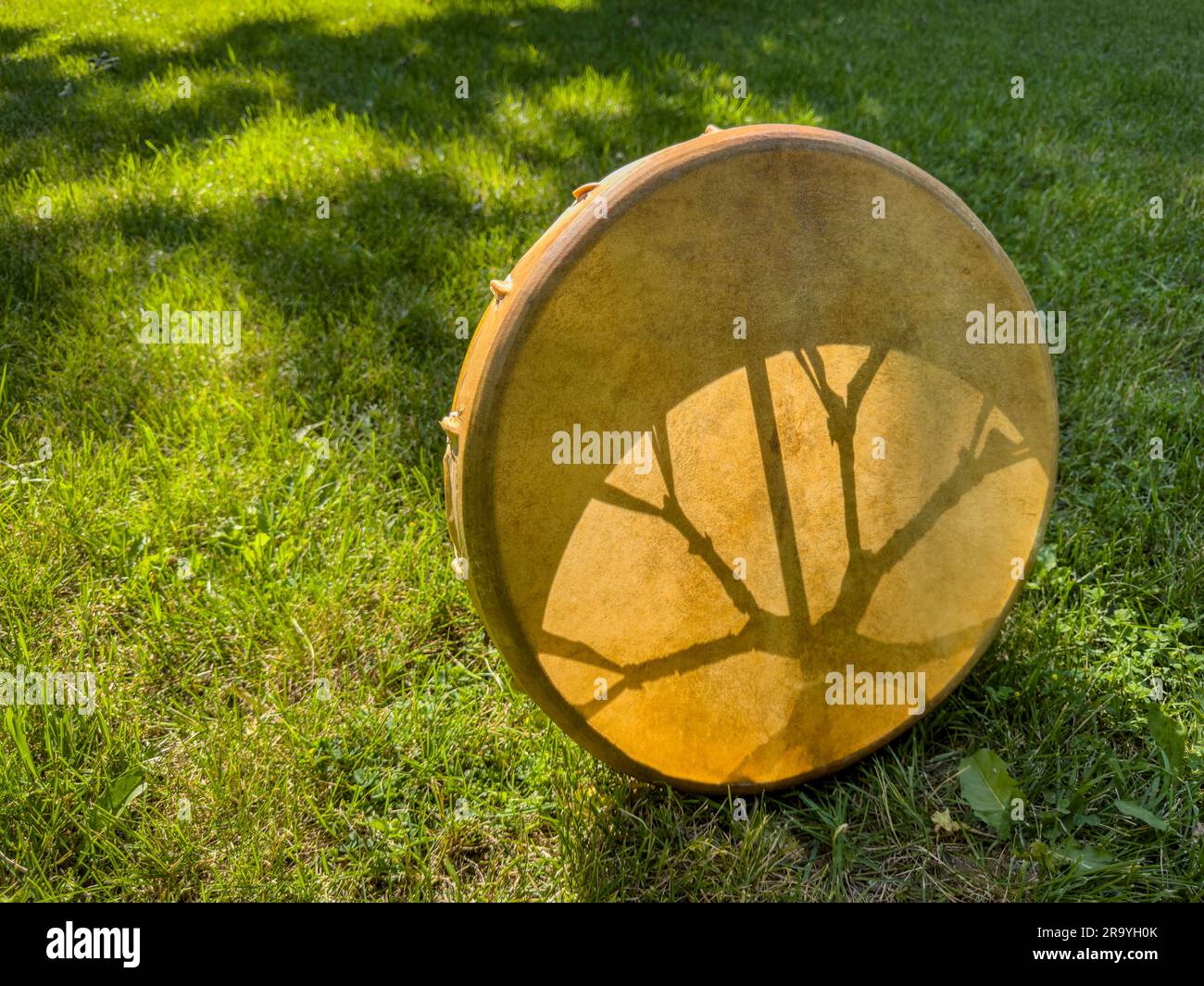 handmade, native American style, shaman frame drum on a grass backlit ...