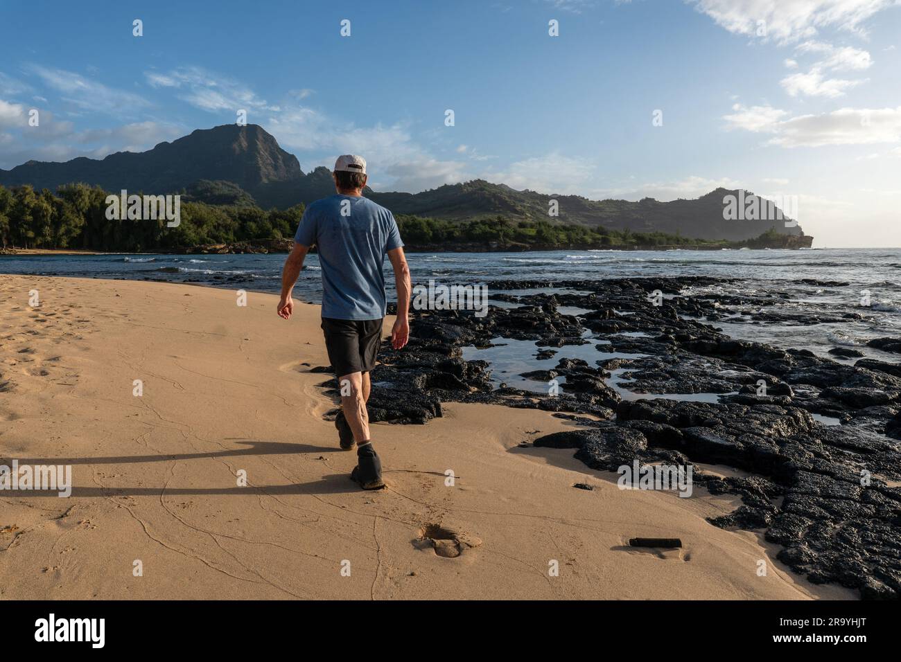 Matured Caucasian man, hiker, close, walking along a sandy beach near ...