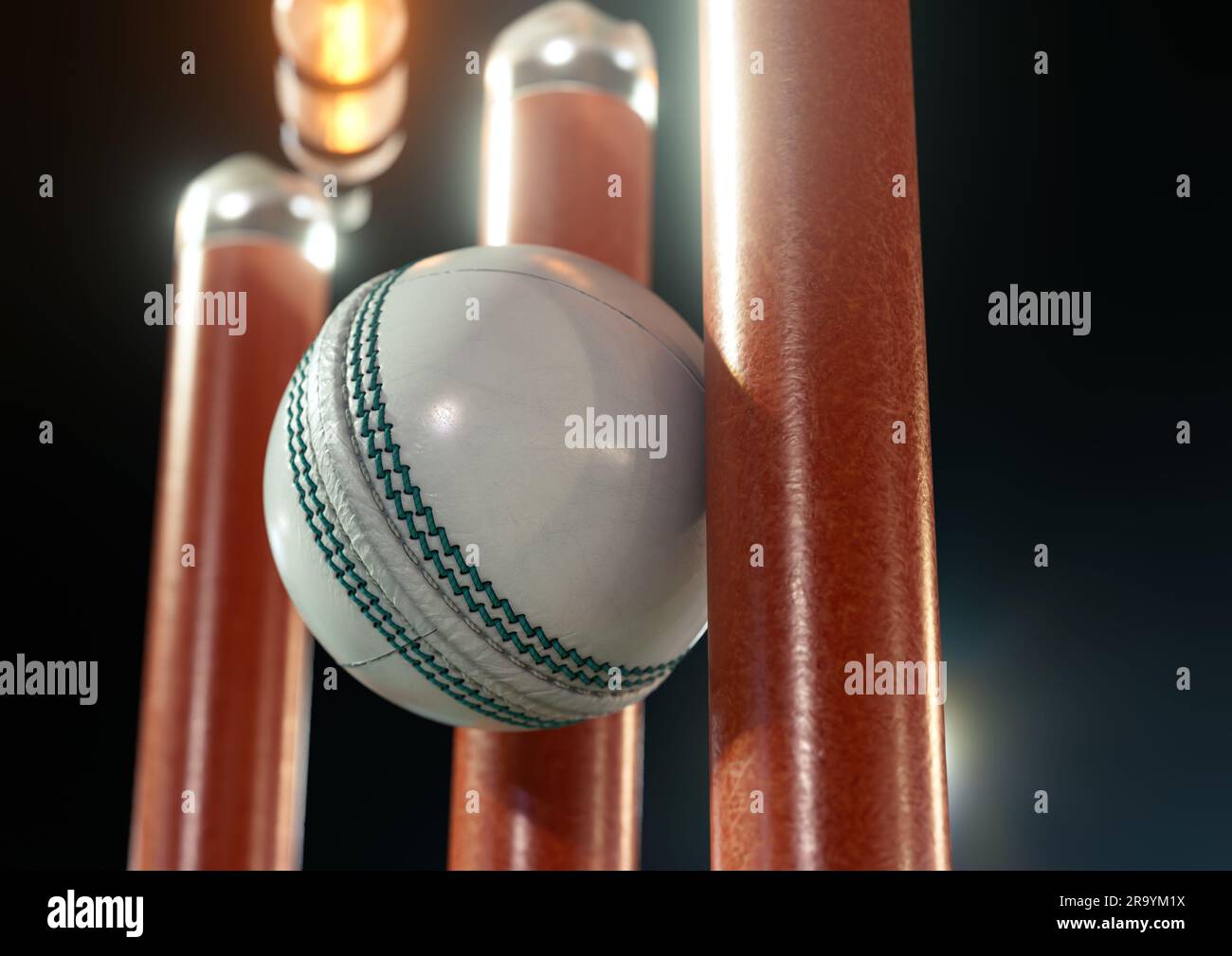A white cricket ball striking orange electronic cricket wickets with ...