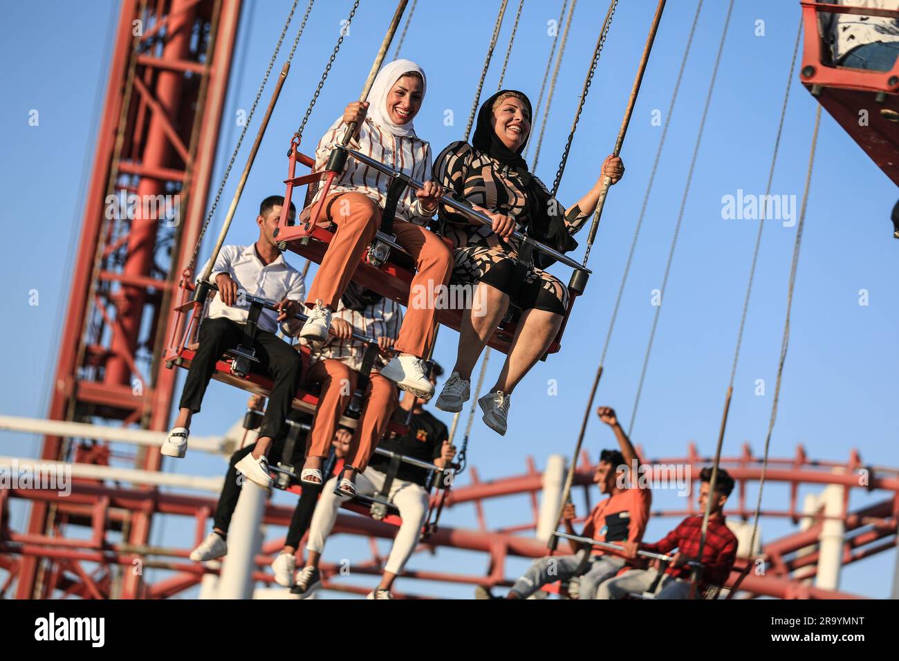 Baghdad, Iraq. 29th June, 2023. People ride on a swing carousel at Al ...
