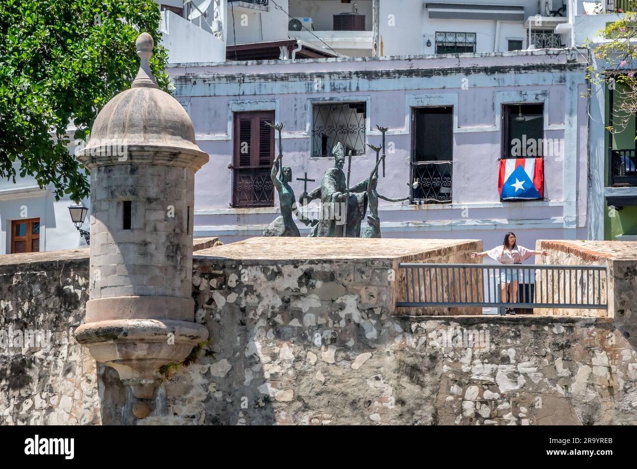 A woman taking in the view from the old fortress wall of Old San Juan ...