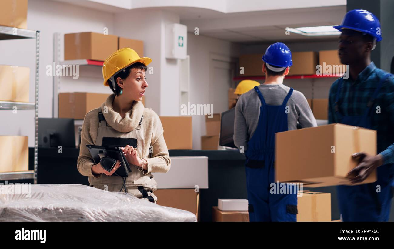 Depot supervisor scanning barcodes on boxes in storage room, working ...