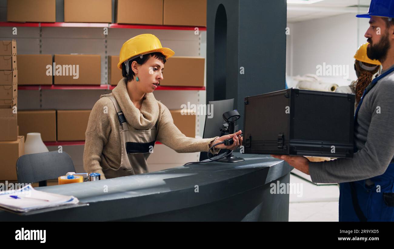 Depot manager checking merchandise with barcodes in warehouse space ...