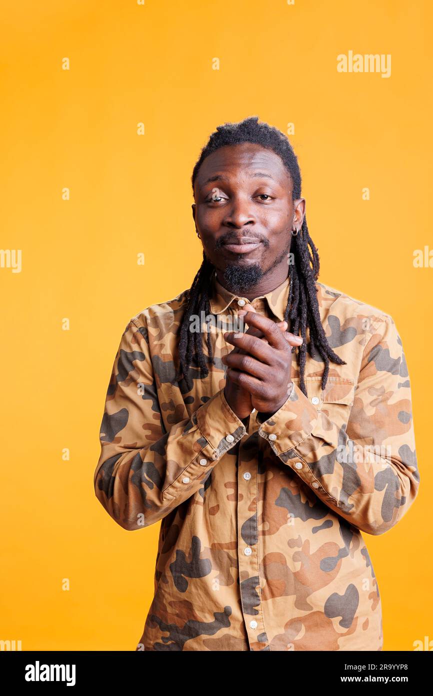 Successful positive man standing with palms together, asking for ...