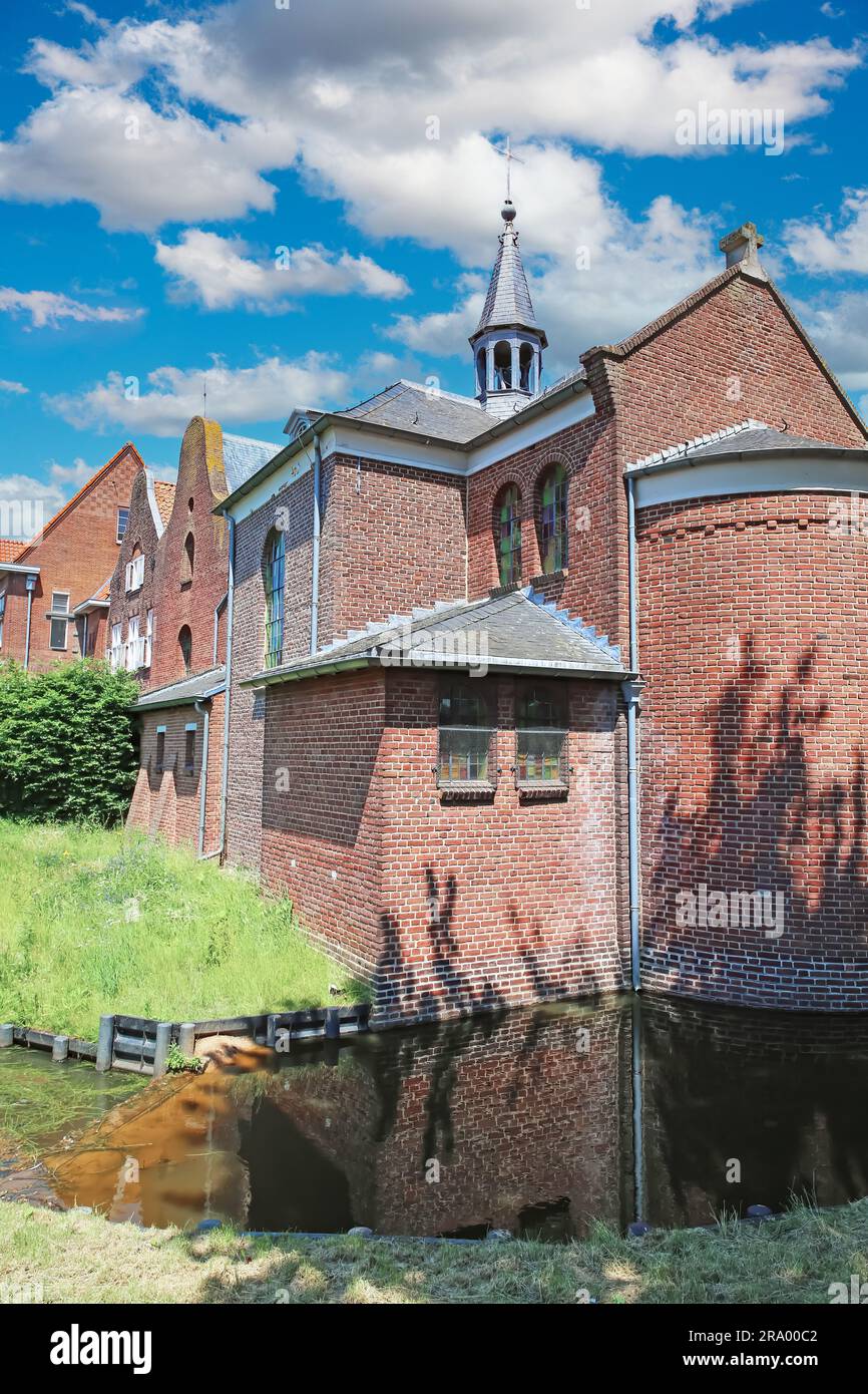 Water moat with ancient red brick stone dutch historic monastery, blue ...