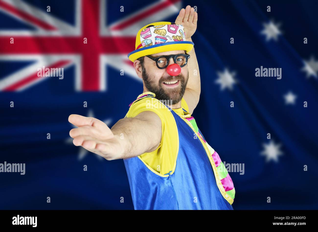 A cheerful clown stands in a greeting pose against the background of ...