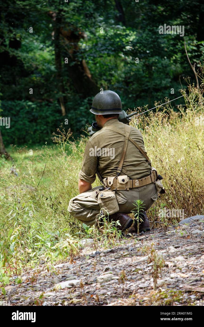 A vertical rear view of an army officer in a military outfit kneeling ...